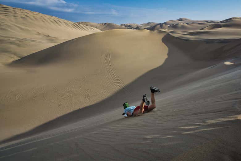 Sandboarding o sand skiing en el desierto de la Huacachina, Ica